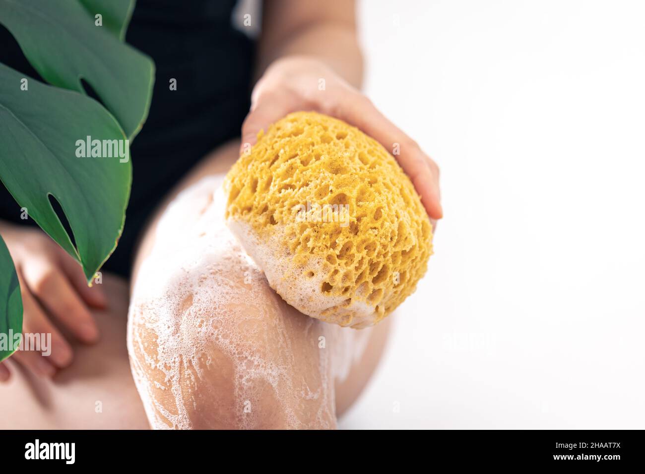 Young woman washing legs with yellow sponge and soap foam Stock Photo ...
