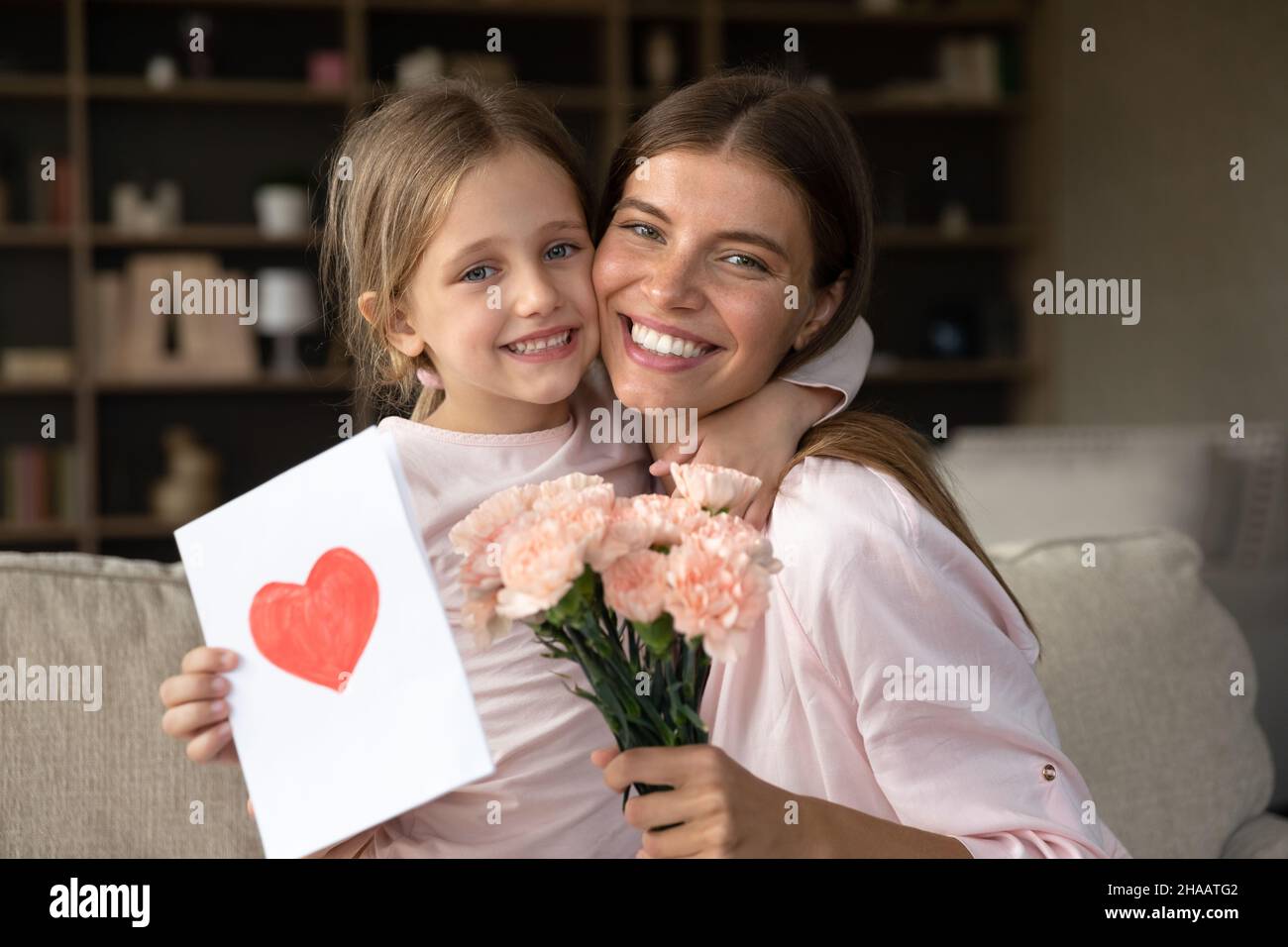 Grateful mom hugging daughter girl, holding flowers bouquet Stock Photo ...