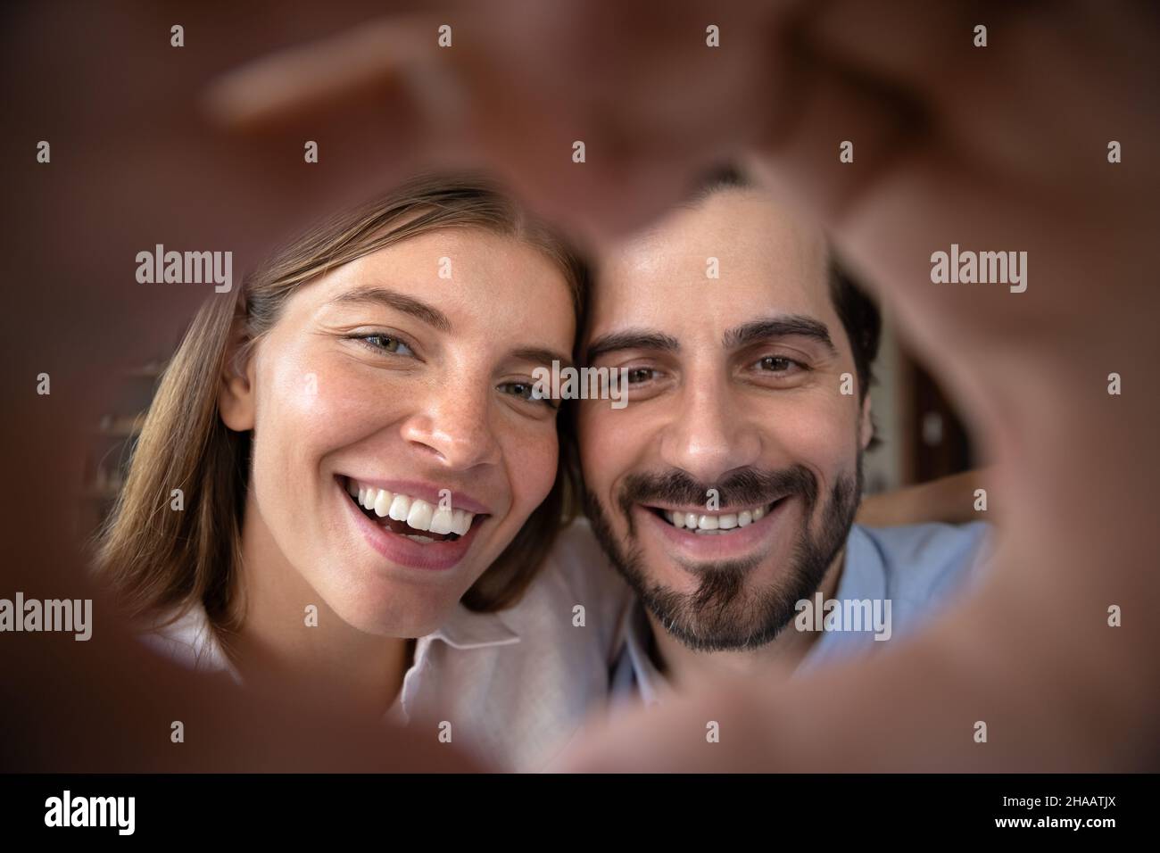Happy excited married couple portrait with hand heart shaped frame ...
