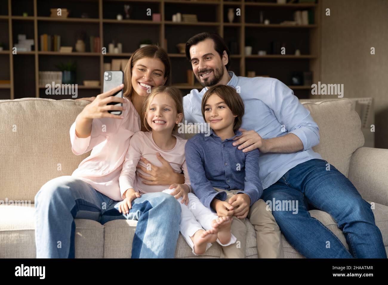 Happy excited parents, little son and daughter resting on couch Stock Photo - Alamy