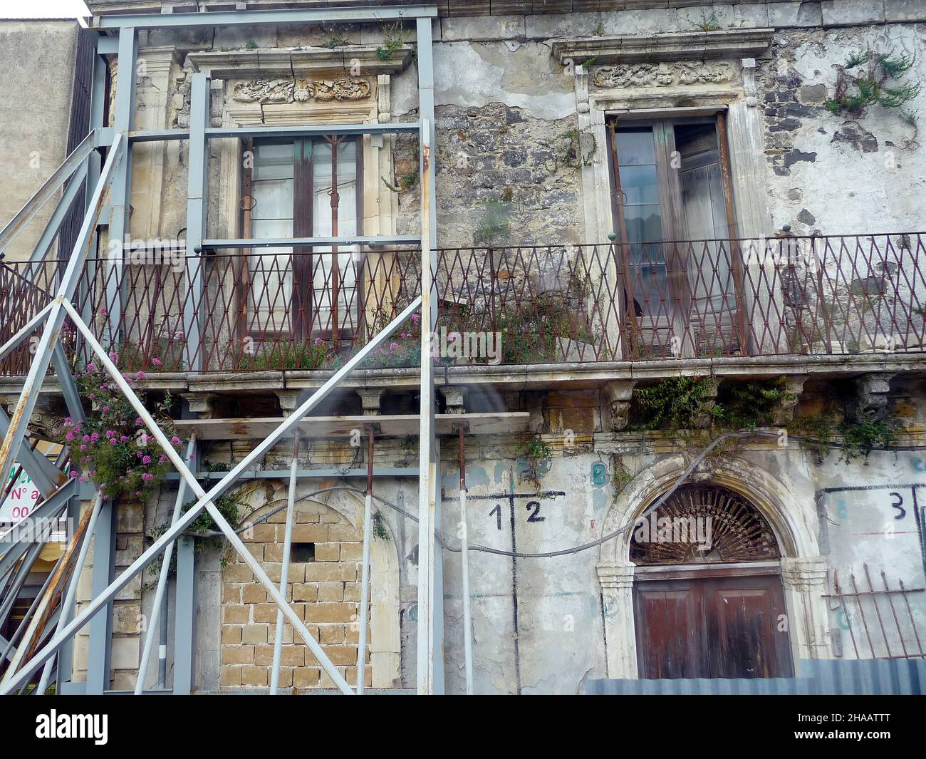 A vertical shot of an old rusty home with two floors, old wooden ...
