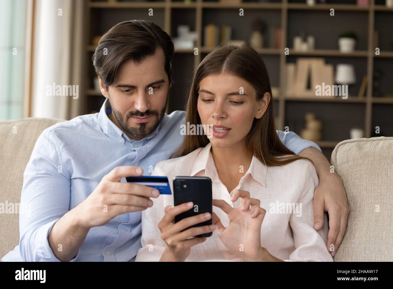 Focused millennial couple of consumers using banking app Stock Photo ...