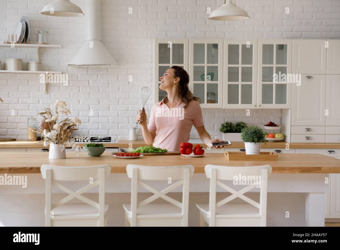 Cheerful excited homeowner woman enjoying cooking in kitchen Stock ...