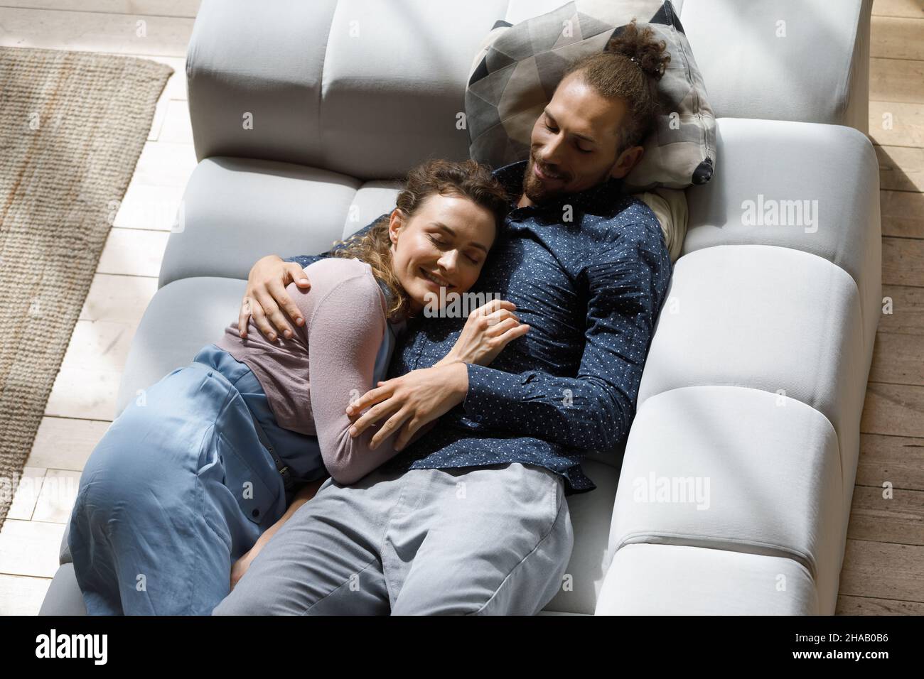 Happy peaceful couple resting on soft couch, lying together Stock Photo ...