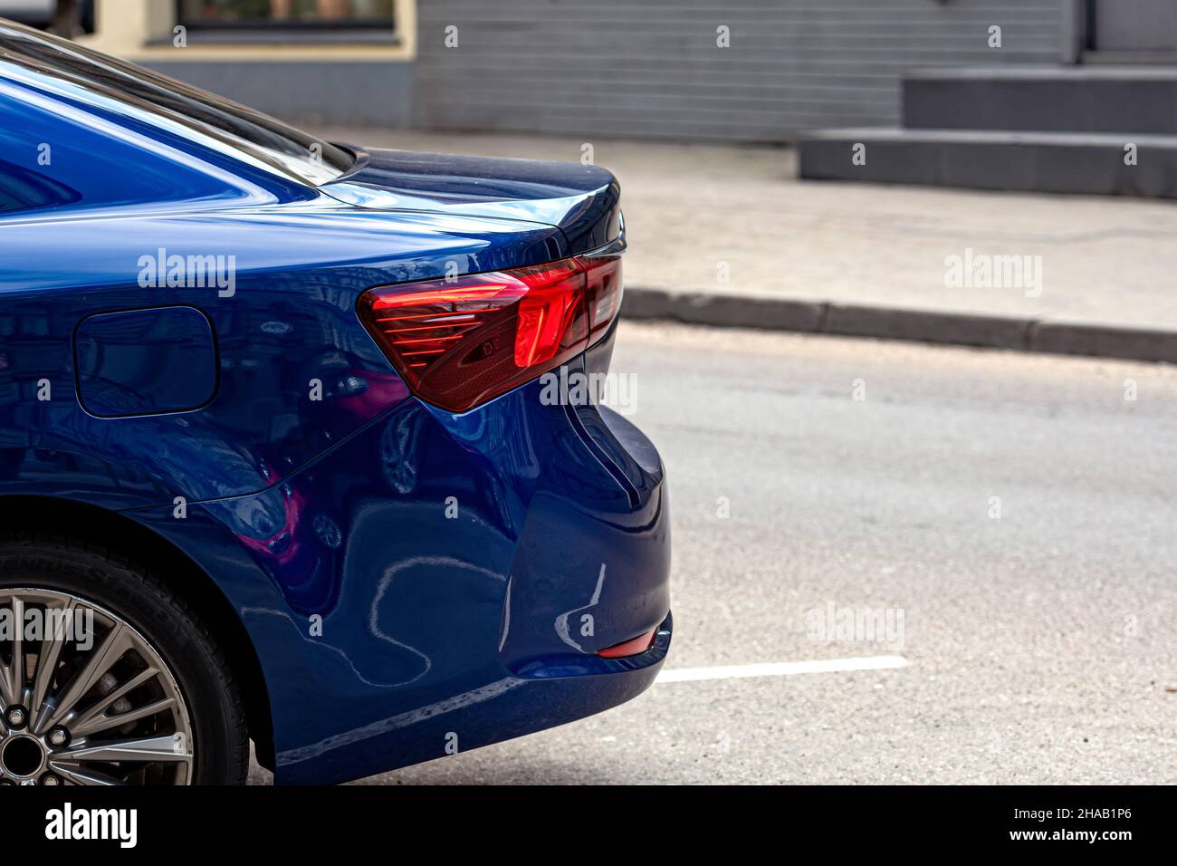rear half with rear lights of a parked car on the side of the street ...