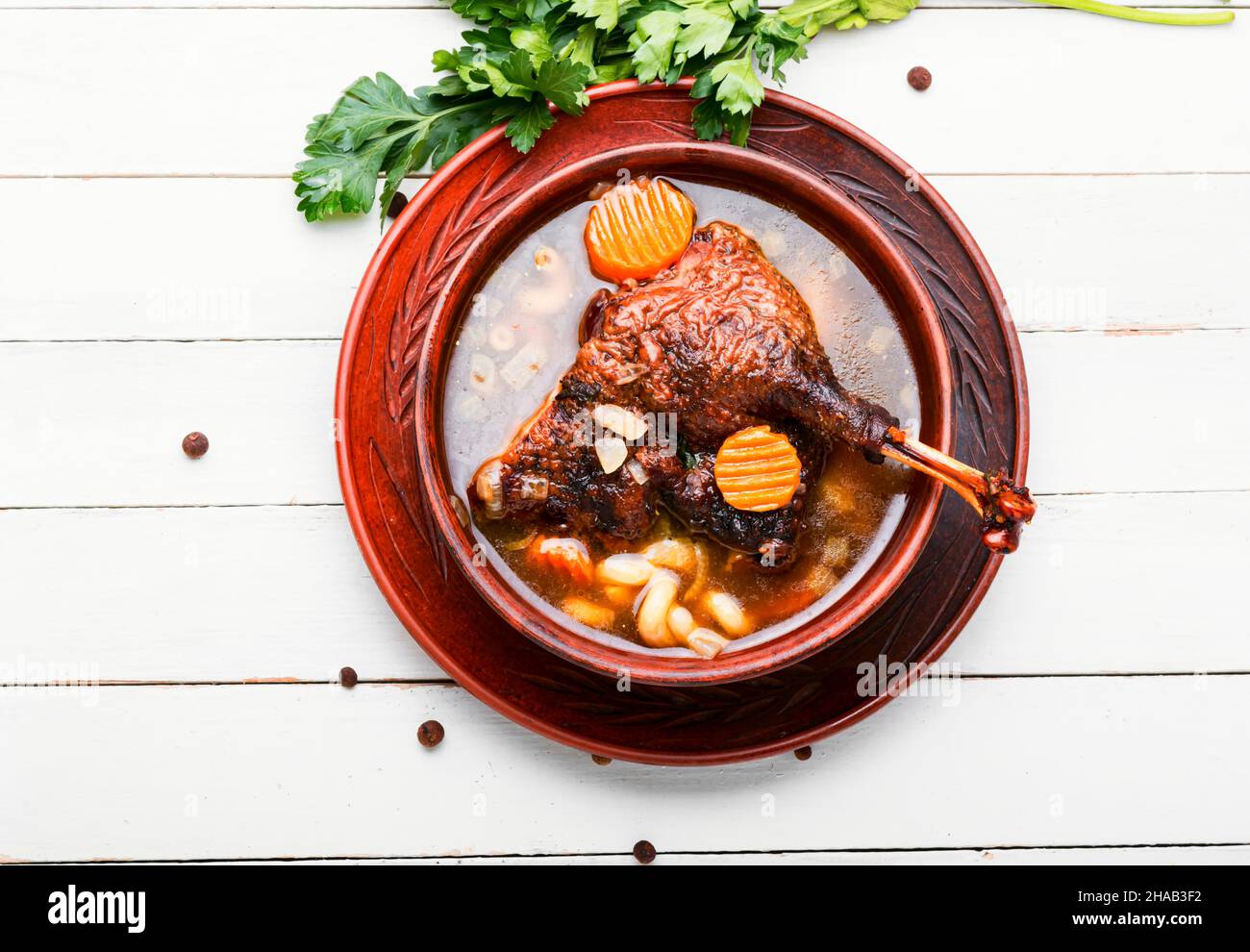 Aromatic goose leg soup with pasta on white background Stock Photo - Alamy