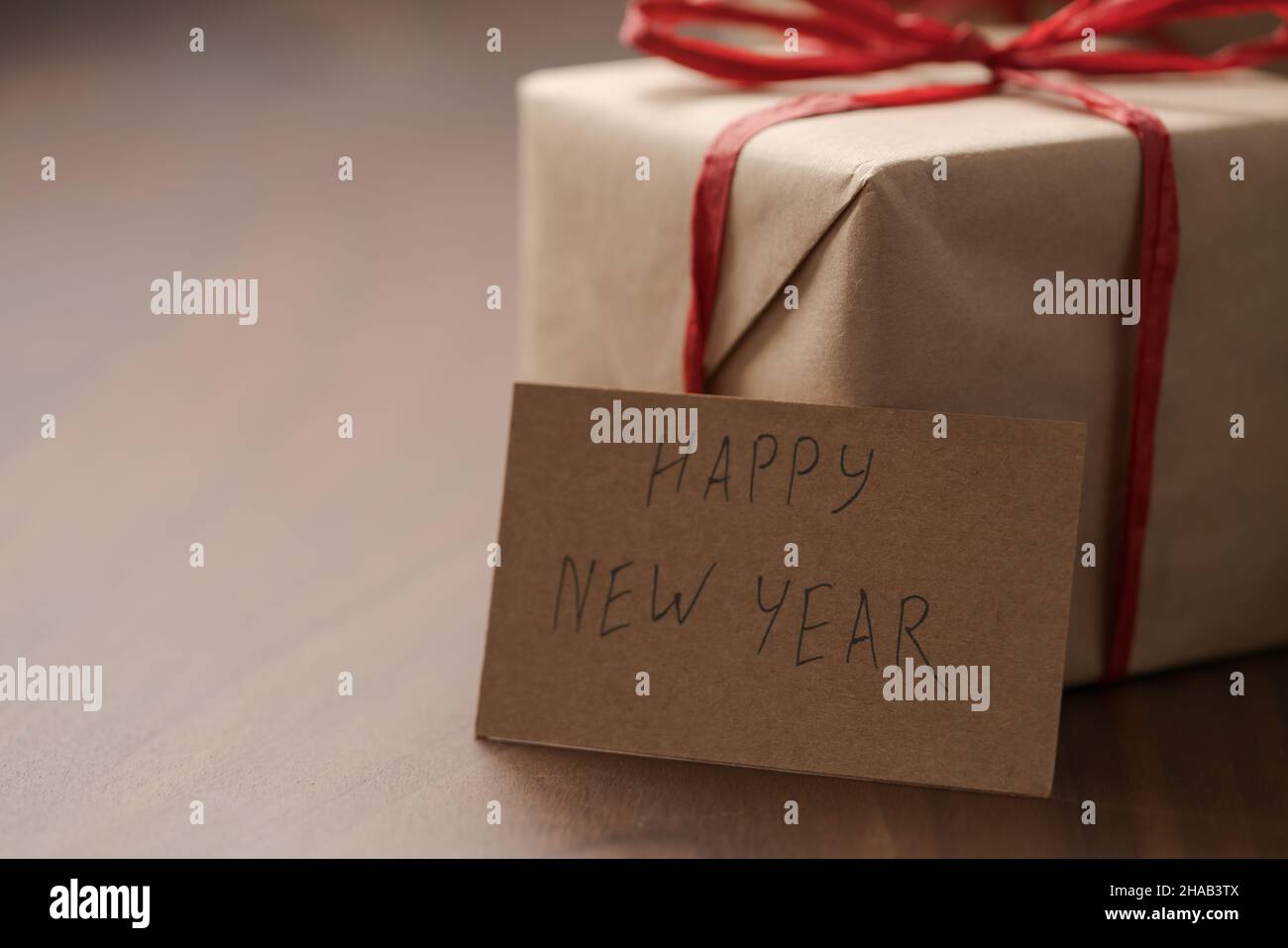 Brown paper gift boxes with red bow and Happy New Year paper card on ...