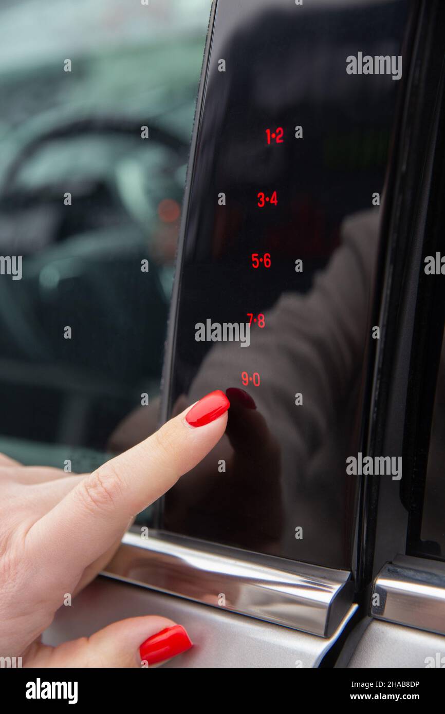 A woman's hand enters the secret code for opening the car door on the ...