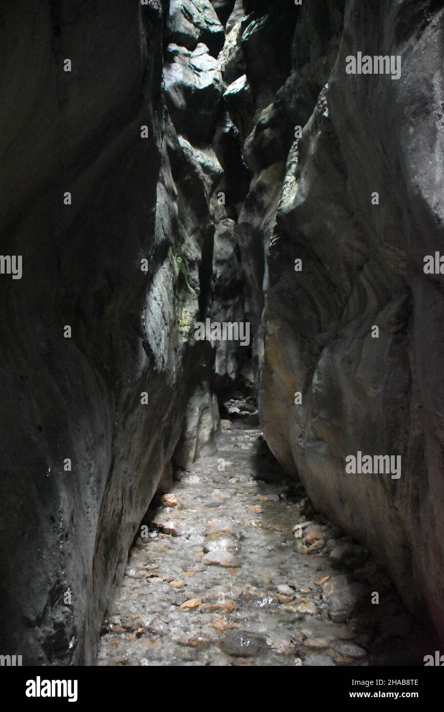 A view inside the cave with rays of light and small stones in a shallow ...