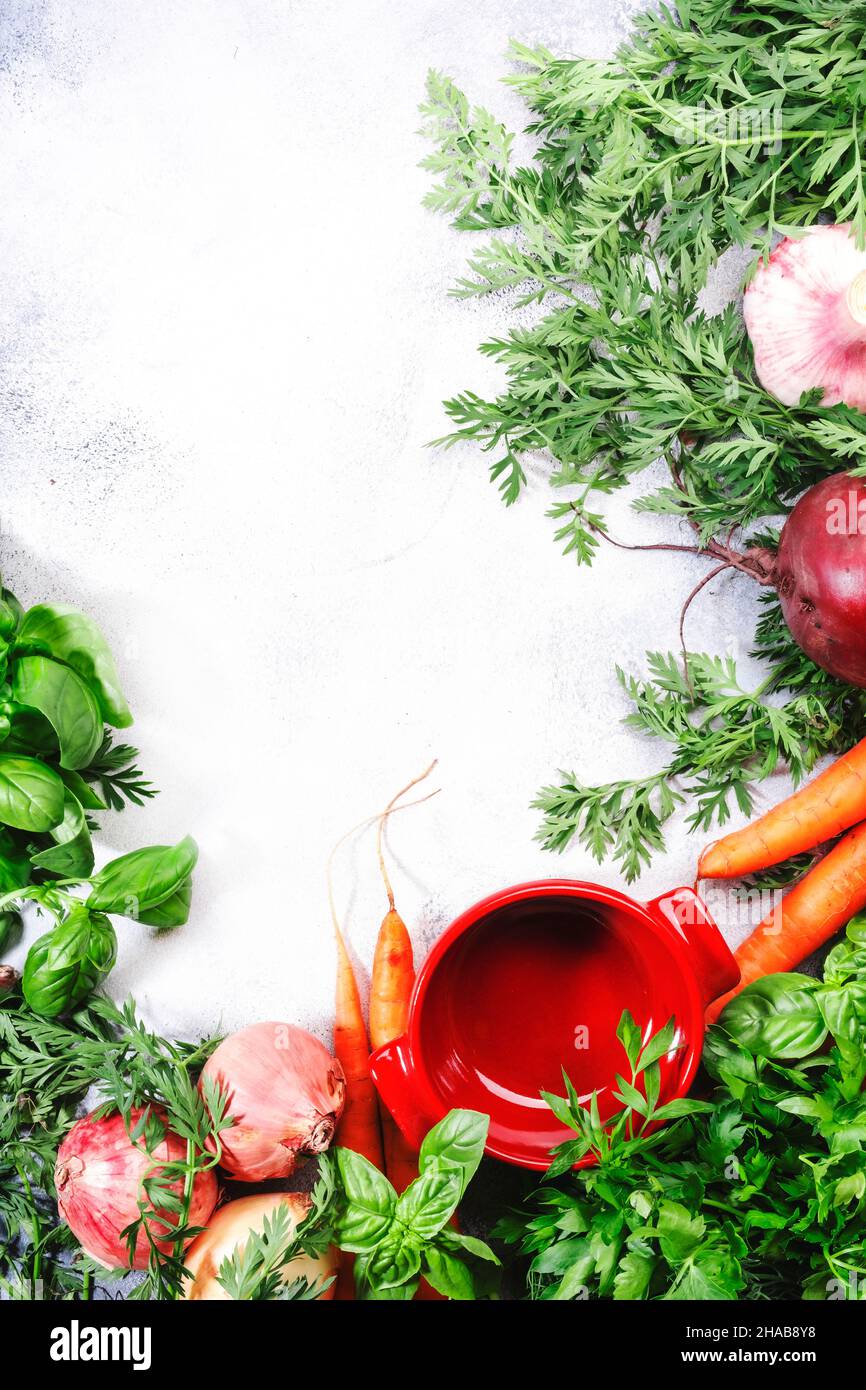 Fresh spring root vegetables and spicy herbs and red pan. Healthy food ...