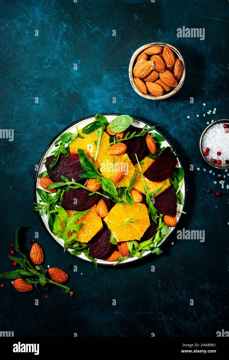 Beet Salad with orange, arugula and almonds on blue table background ...