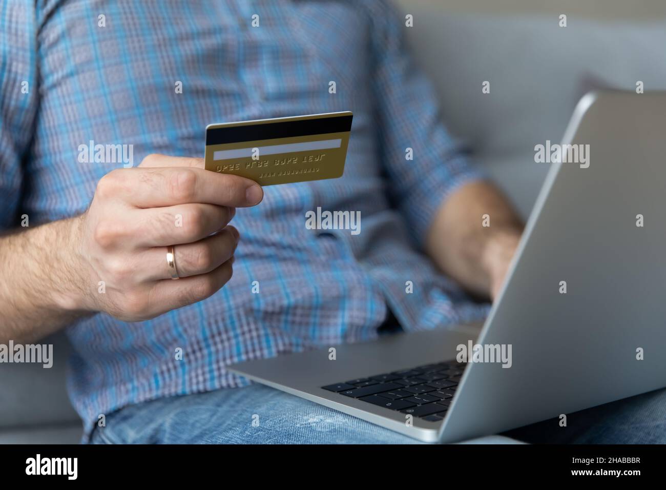 Man sit on sofa with laptop holds card buying online Stock Photo - Alamy