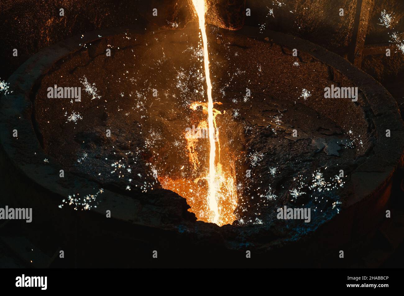 Molten iron. Liquid metal is poured into the ladle in a thin stream ...