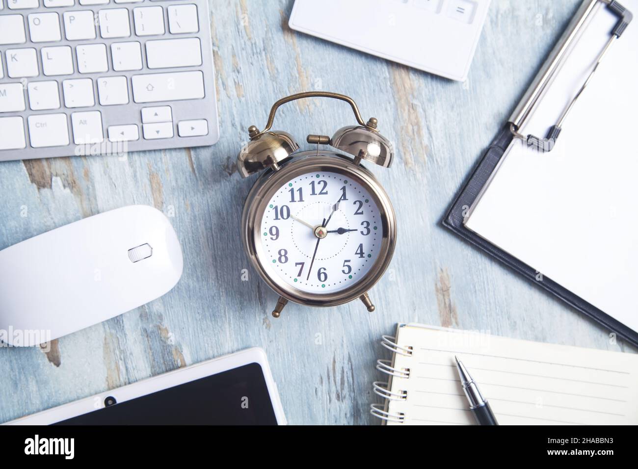 Alarm clock with business object on the desk Stock Photo - Alamy