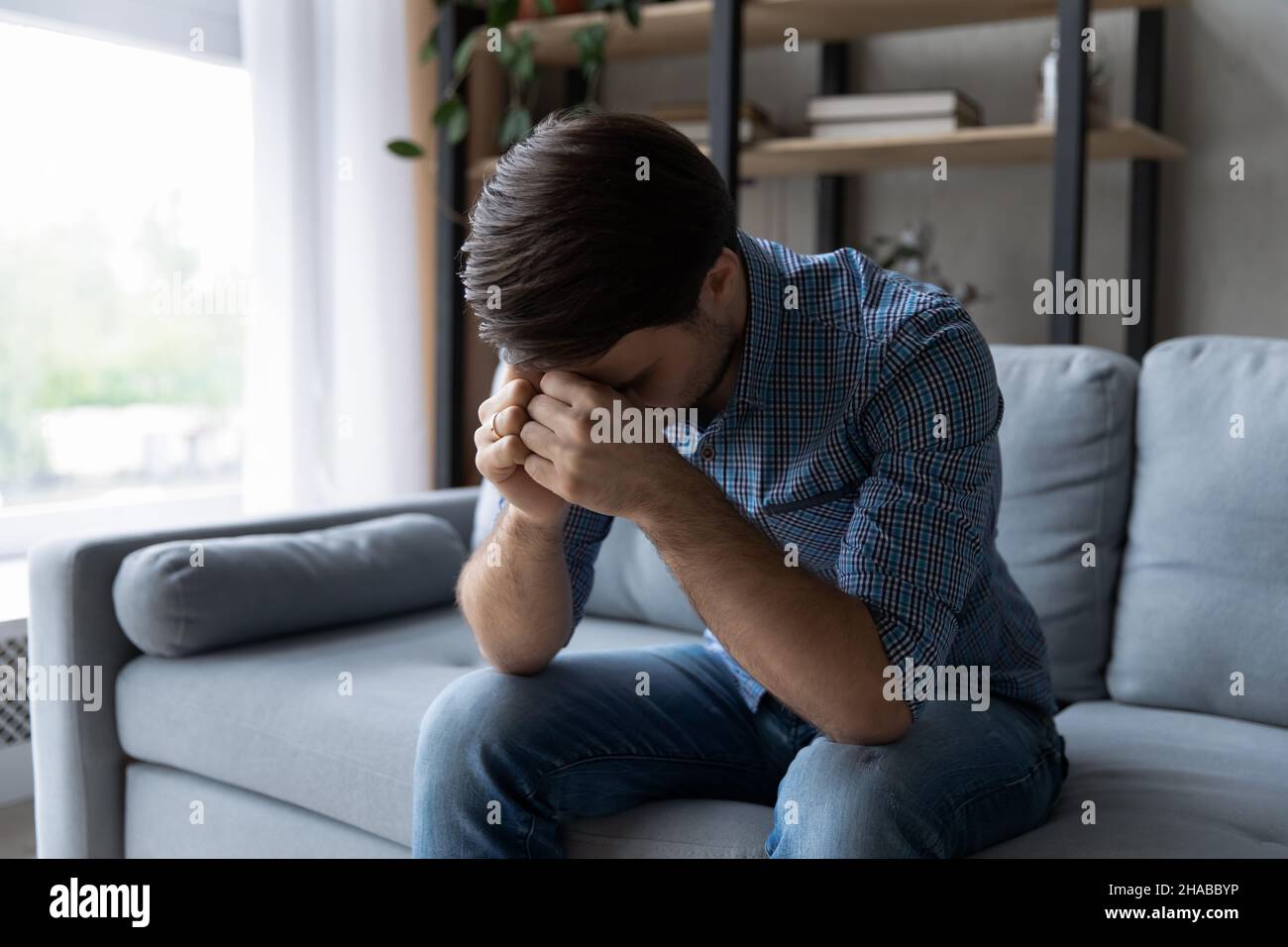 Sad depressed man sit on sofa with head-down Stock Photo - Alamy