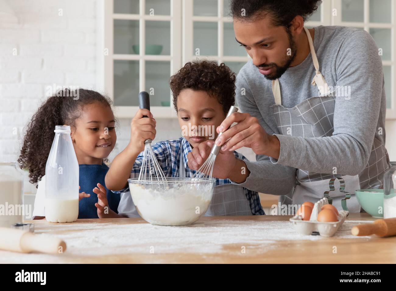 Loving African dad teach kids cooking in kitchen Stock Photo - Alamy