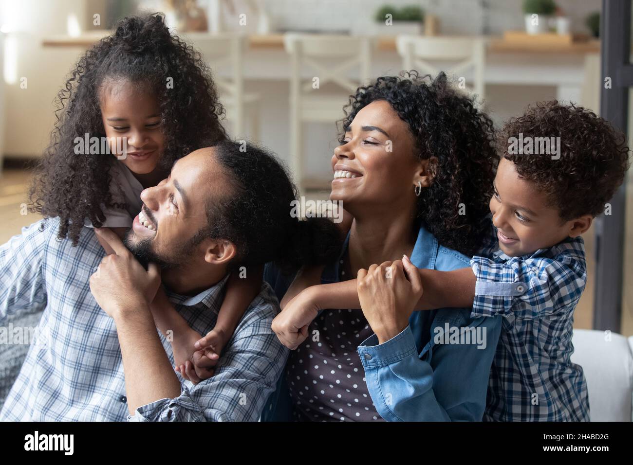 African couple and kids hugging sit on sofa at home Stock Photo - Alamy