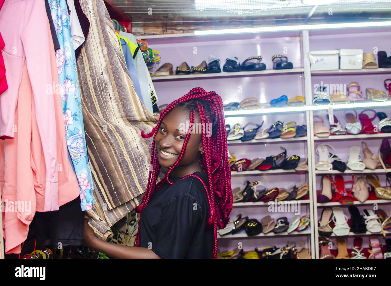 A black beautiful Nigerian girl with rasta red hair holding jackets at ...