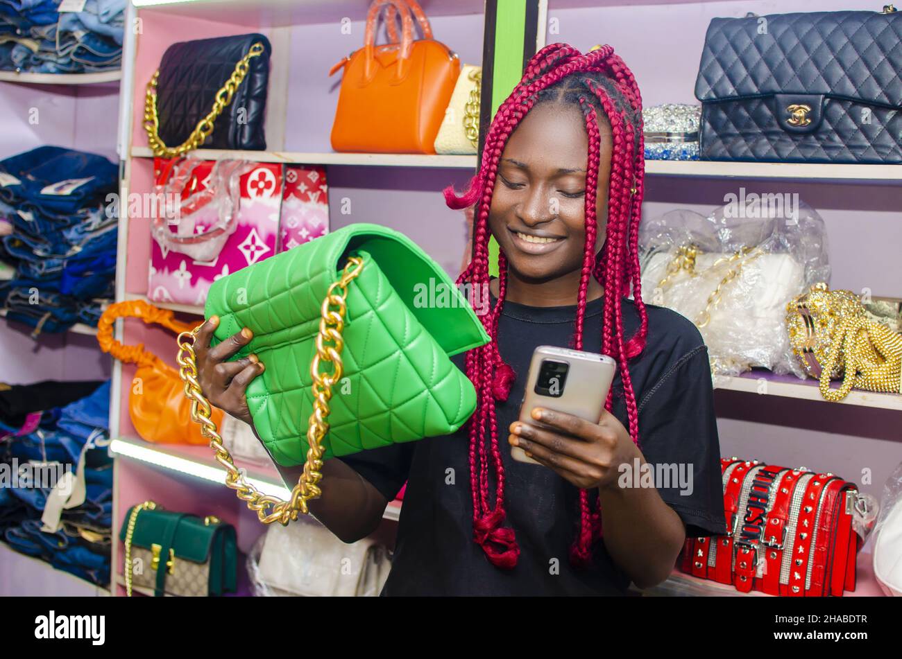 A black beautiful Nigerian girl with rasta red hair holding a phone and ...