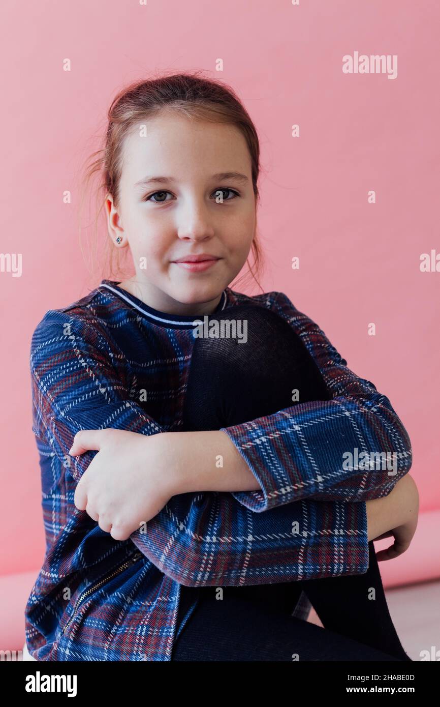 portrait of a beautiful girl student at school on a pink background ...