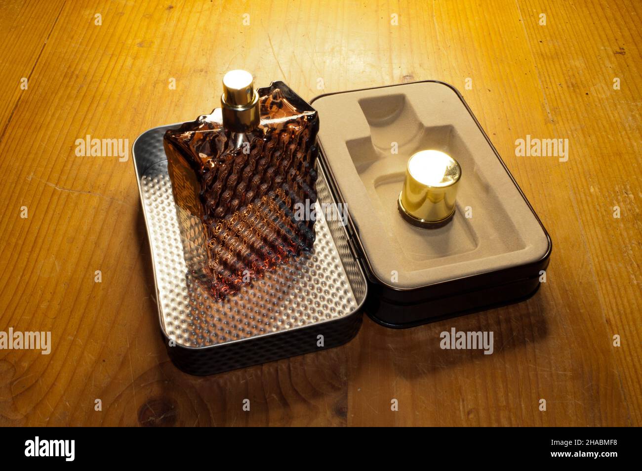 Perfume bottle in opened metal package Stock Photo - Alamy