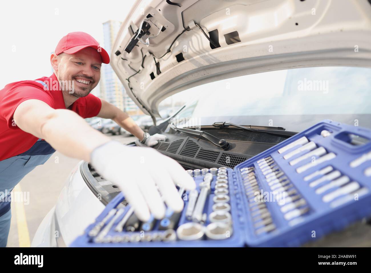 Automotive technician smiling and take instrument from open kit Stock ...