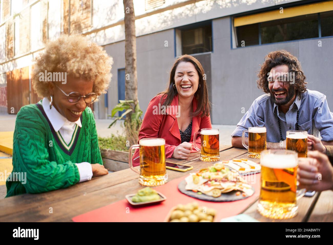 Group of friends drink beer and laughing on the terrace outdoors Stock ...