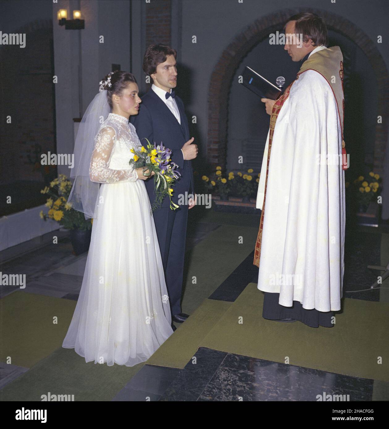 Polska 12.1983. Katolicki œlub koœcielny. Nz. m³oda para sk³ada ...