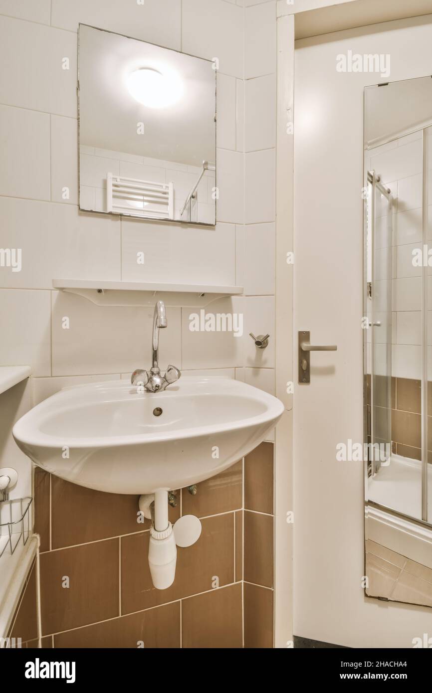 Delightful bathroom with sink and shelf under the mirror Stock Photo ...