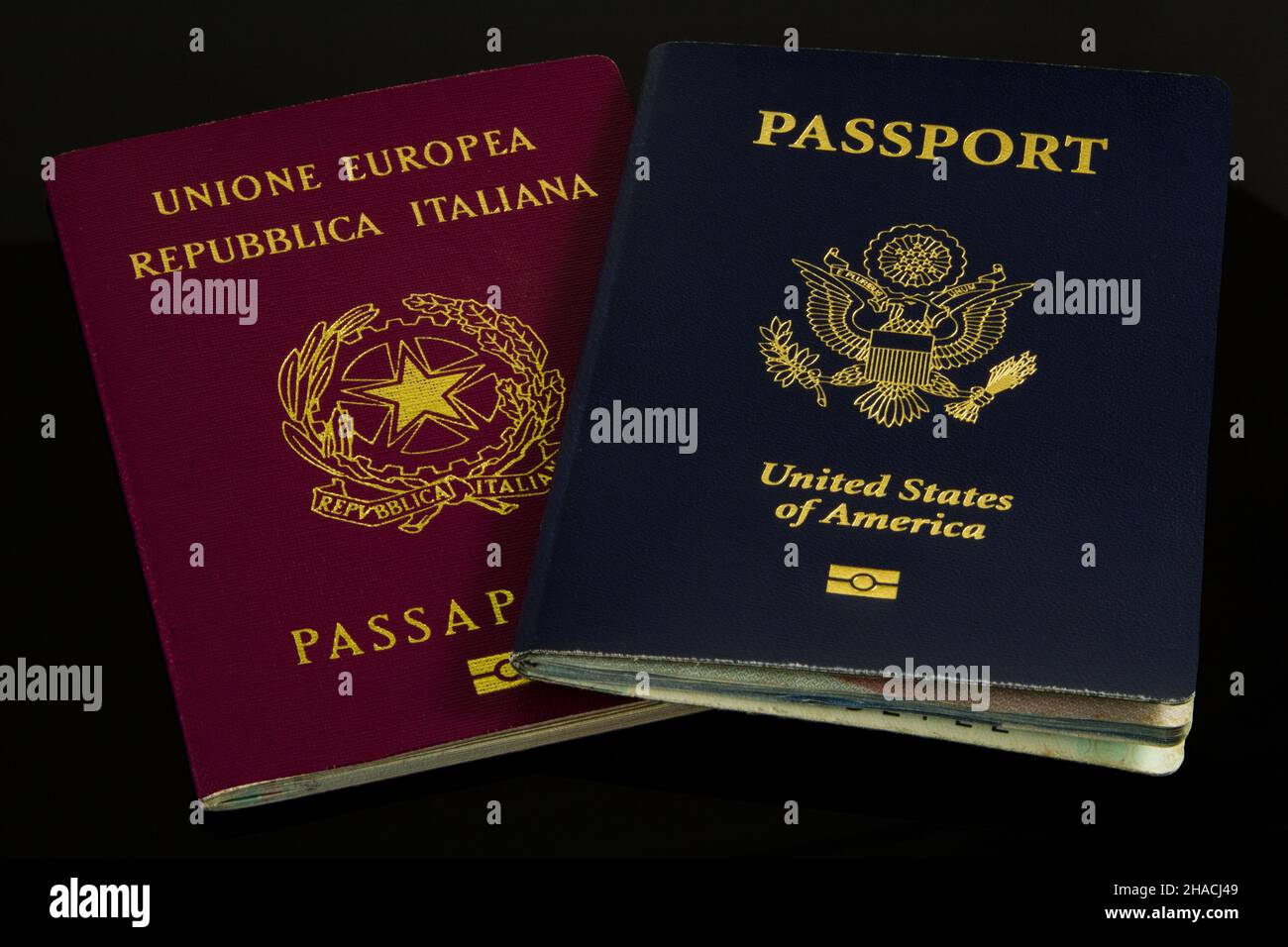 A vertical closeup shot of a dark blue US passport and red Italian ...