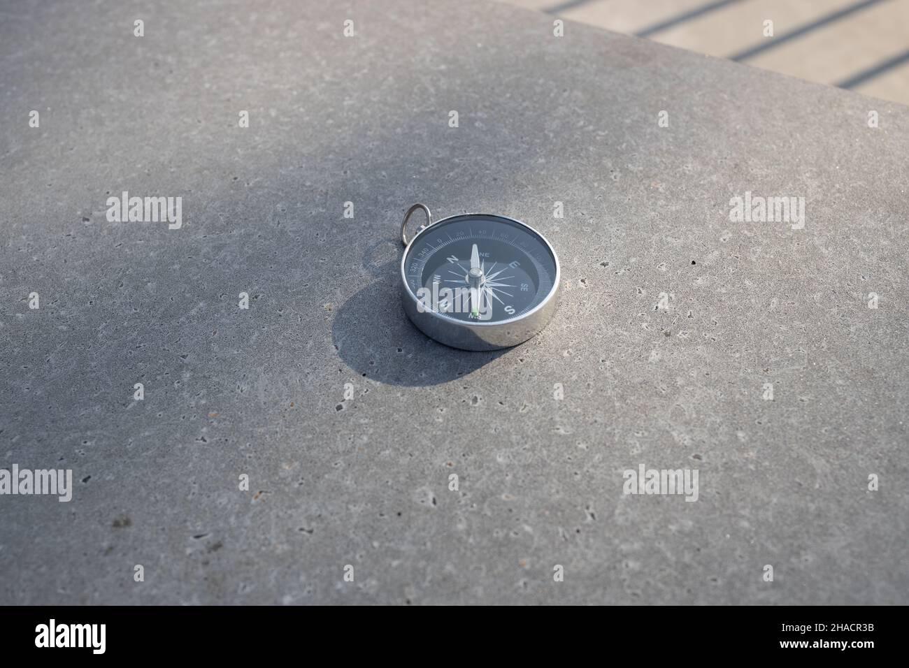Round stylish compass on concrete background, search direction with ...