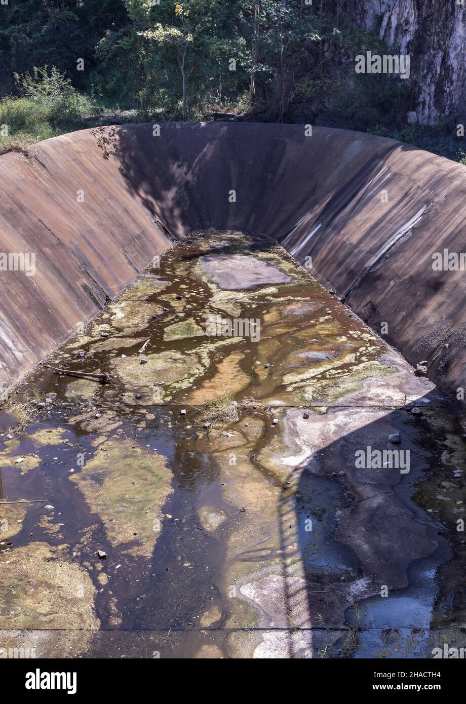 Dried up empty reservoir or small concrete dam due to a summer heatwave ...