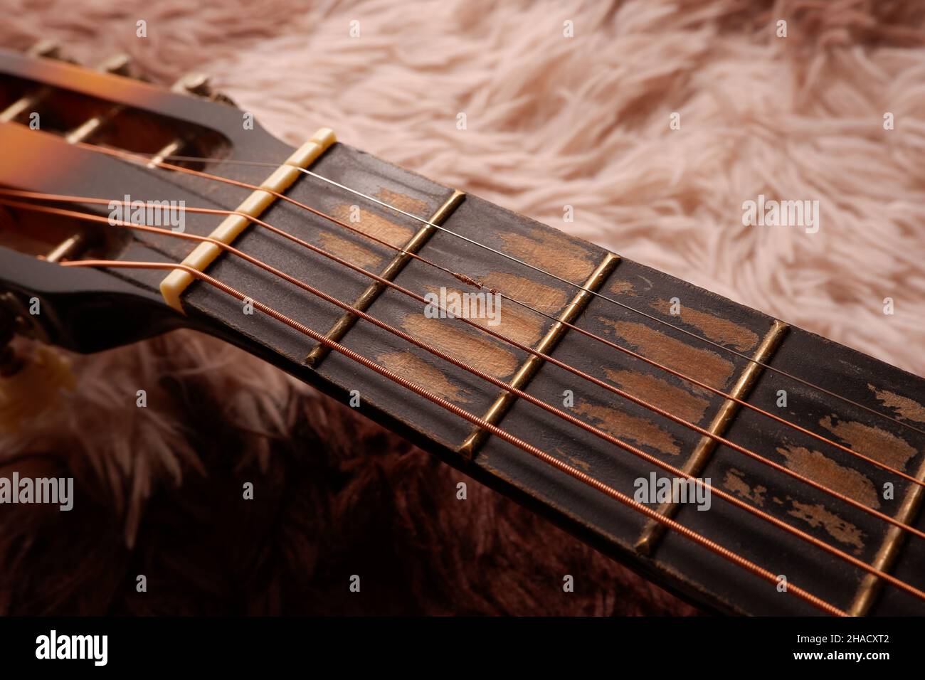 Used guitar with broken metal string on a carpet Stock Photo - Alamy