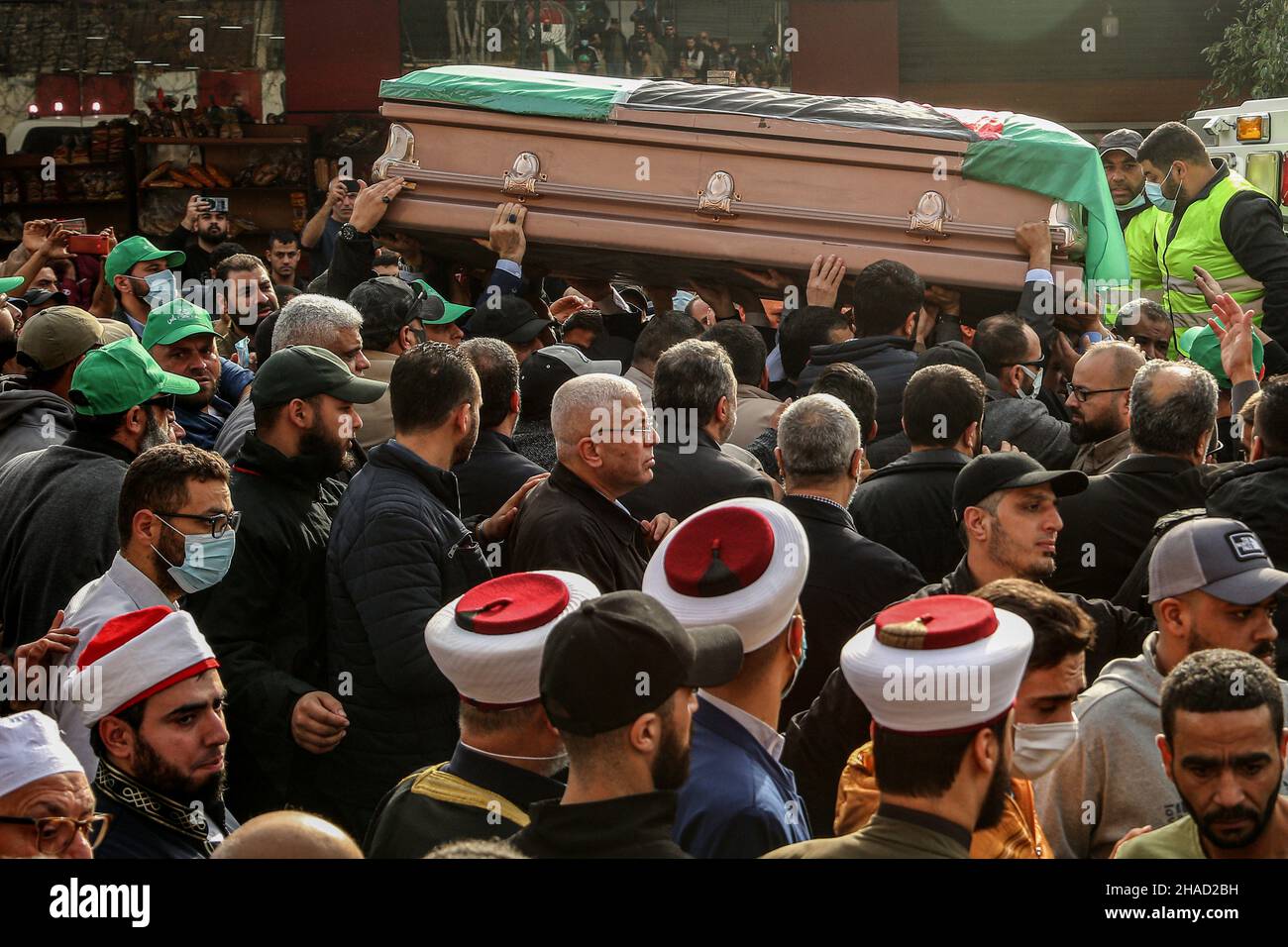 12 December 2021, Lebanon, Tyre: Mourners carry the coffin of Hamza ...