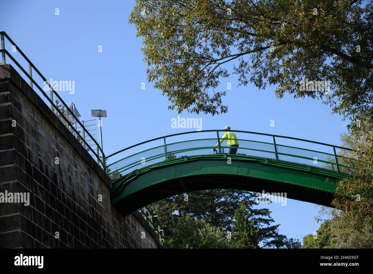 A lone cyclist stands on a steel arch bridge and takes a break Stock ...