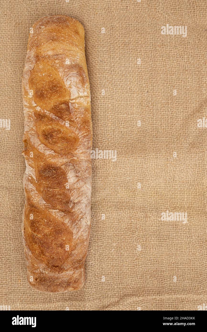whole loaf of fresh bread isolated on burlap, top view, french baguette ...