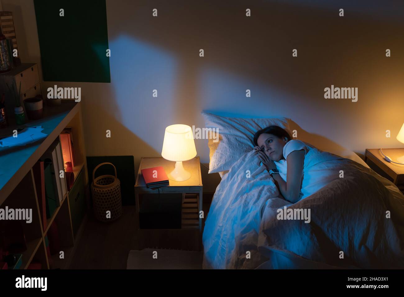 Beautiful girl suffering from insomnia lying in her bed with Blue ...