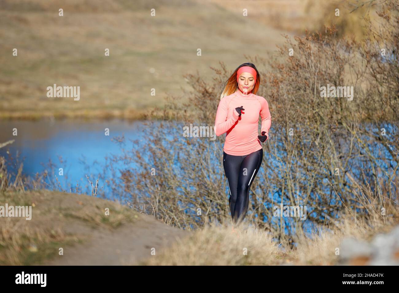 Young fitness woman running in the morning in cold sunny weather Stock ...