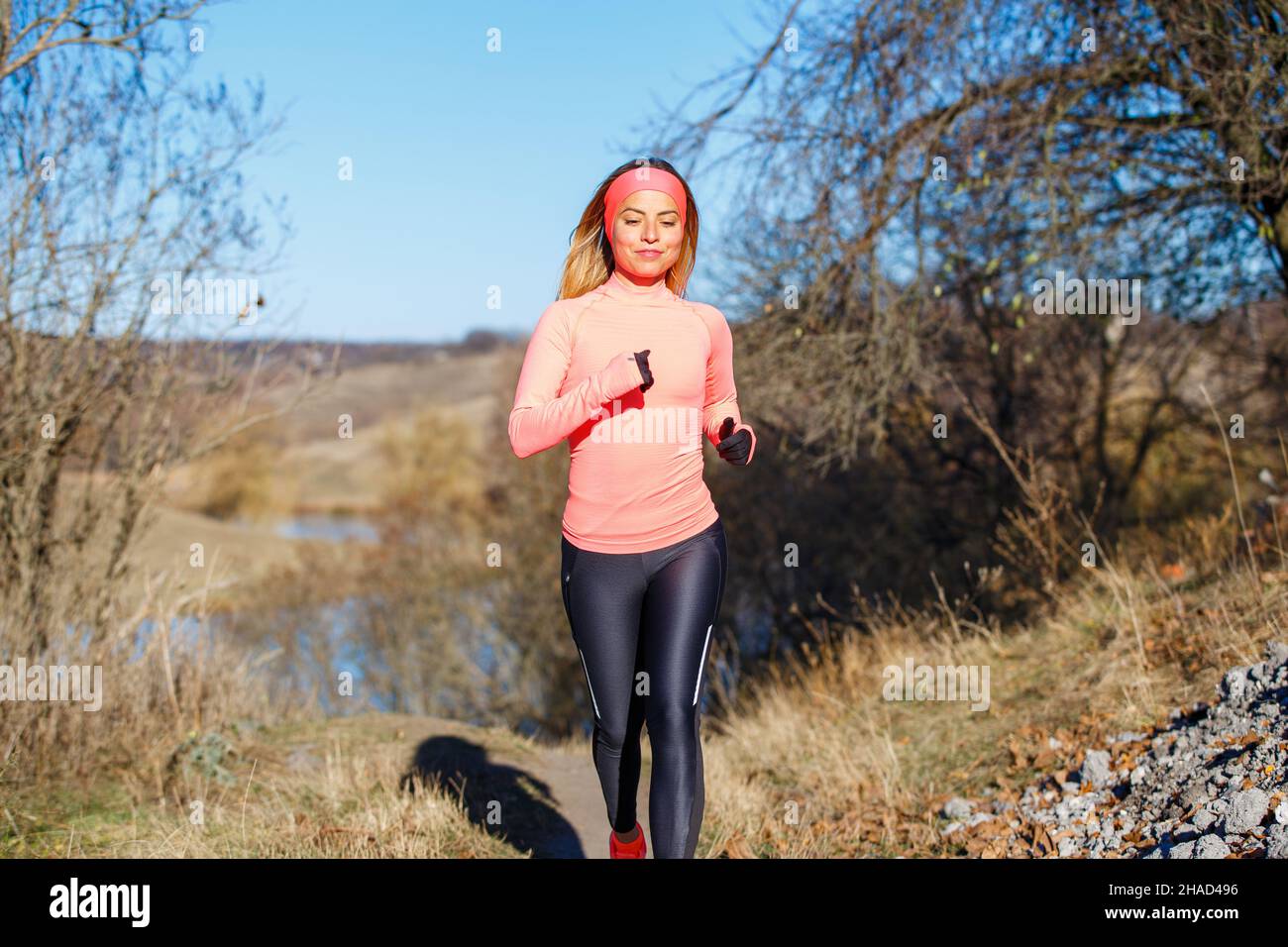 Young fitness woman running in the morning in cold sunny weather Stock ...