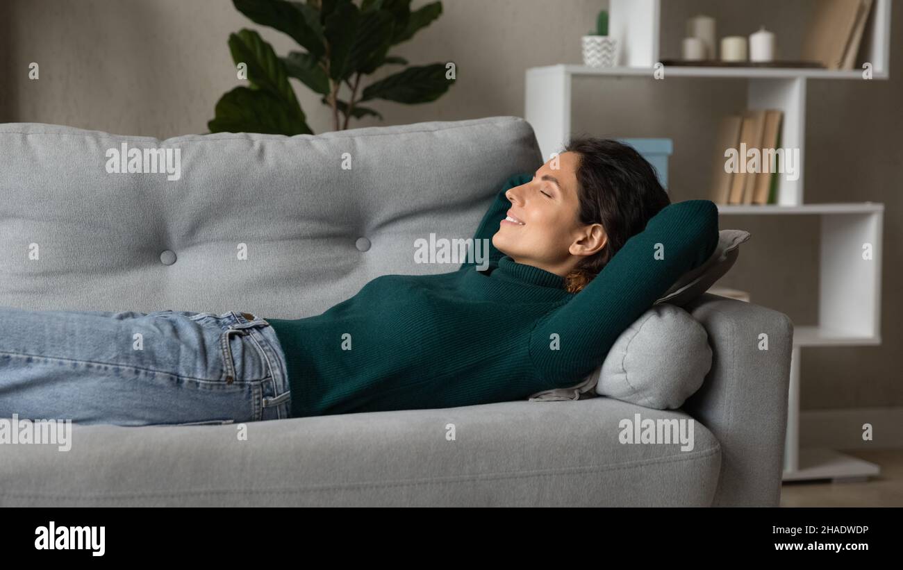 Calm Latino woman rest on sofa sleeping Stock Photo - Alamy