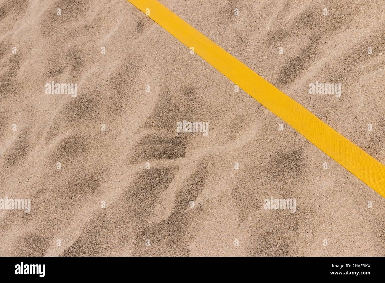 A closeup of a yellow strip line on the sand Stock Photo - Alamy