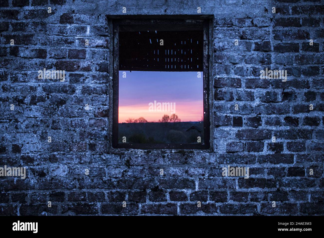 A scenic purple sunset view through a window in a brick wall Stock ...