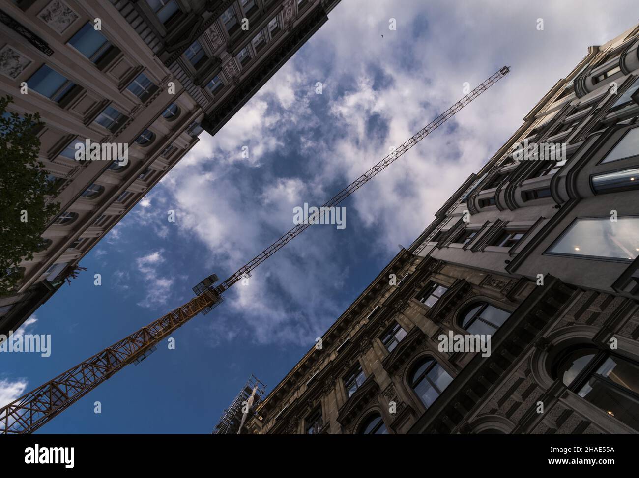 A low angle view of a construction crane and high rise buildings in the ...