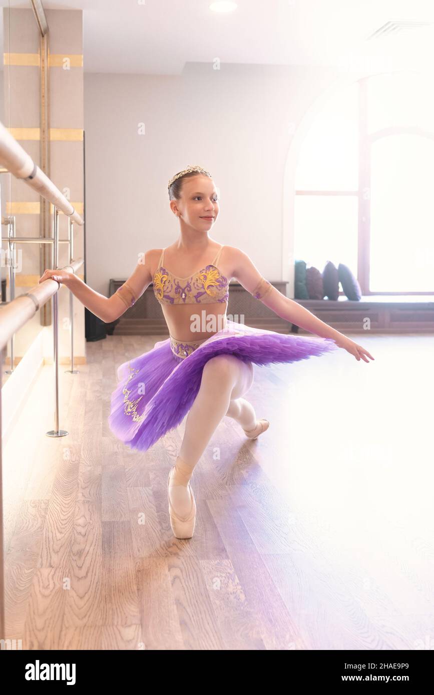 little girl wear pointe in ballet class near frame and large mirror ...