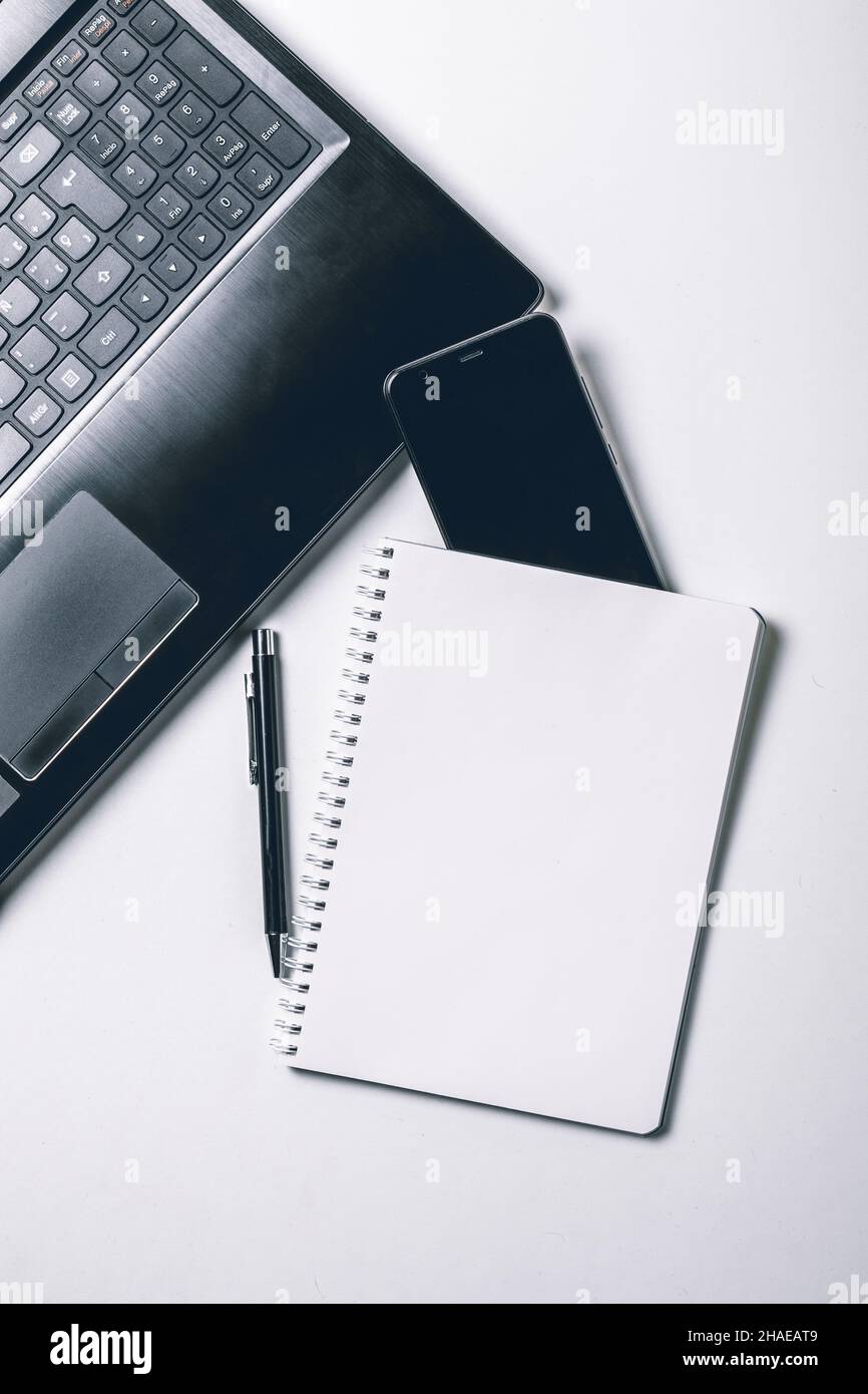 Modern white office desk table with laptop, smart phone and pen. Blank ...