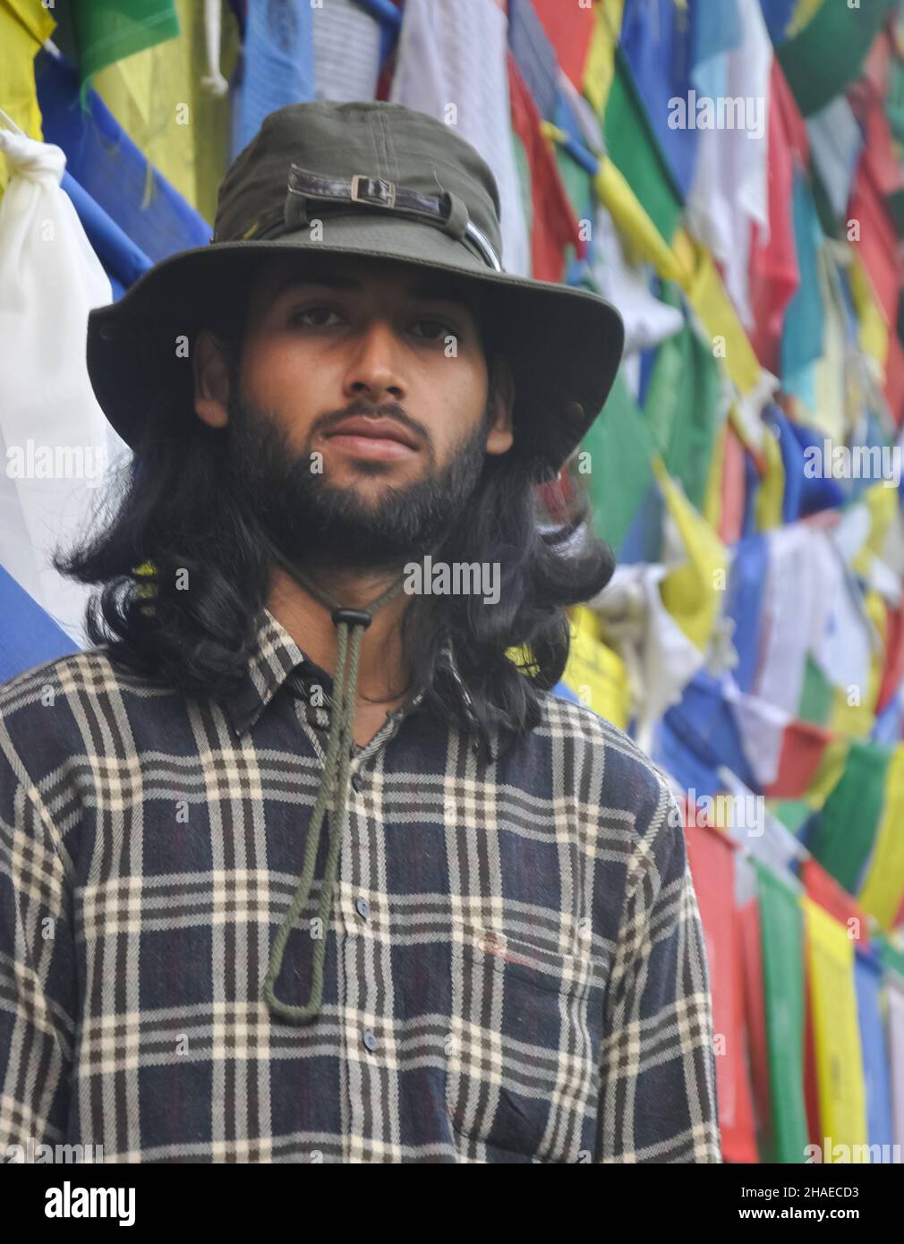 A bearded and long haired male tourist looking at camera while standing ...