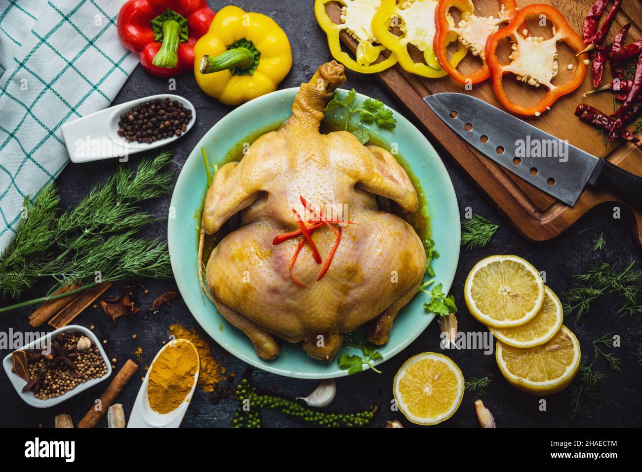 View from above of whole chicken with lemon and and various vegetables ...