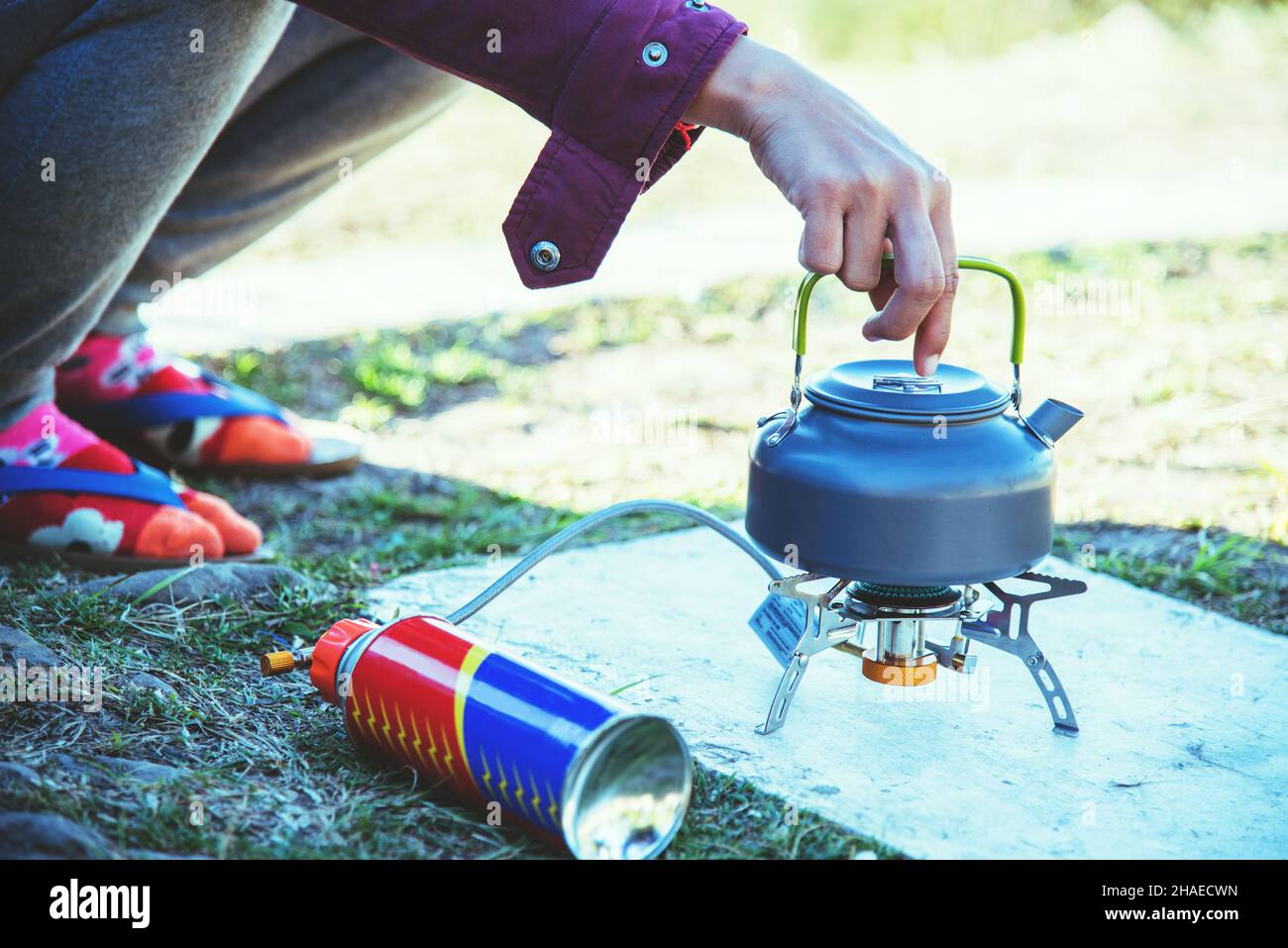 Woman hand is holding a kettle. Placed on a picnic gas stove Stock ...