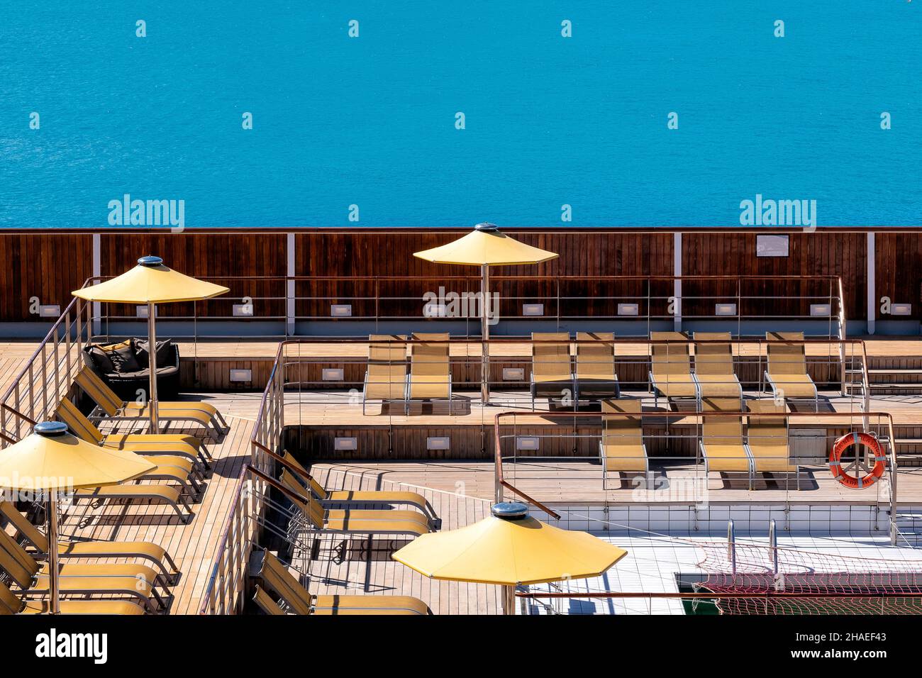 A retro swimming pool deck on a old cruise ship, empty sunchairs and no ...