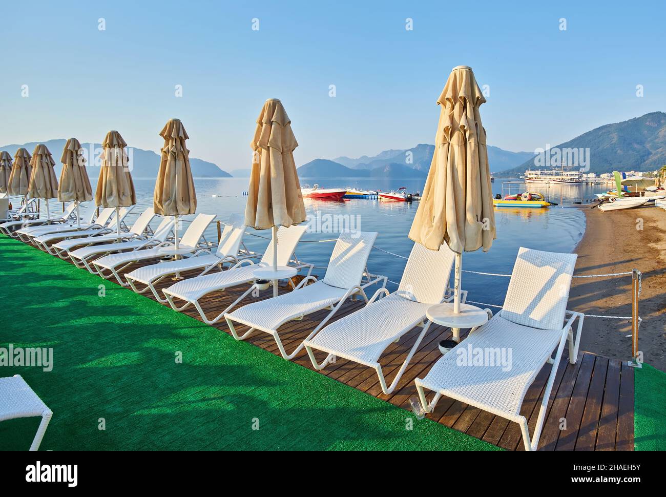 sandy beach without people and with sun loungers, umbrellas, palm trees ...